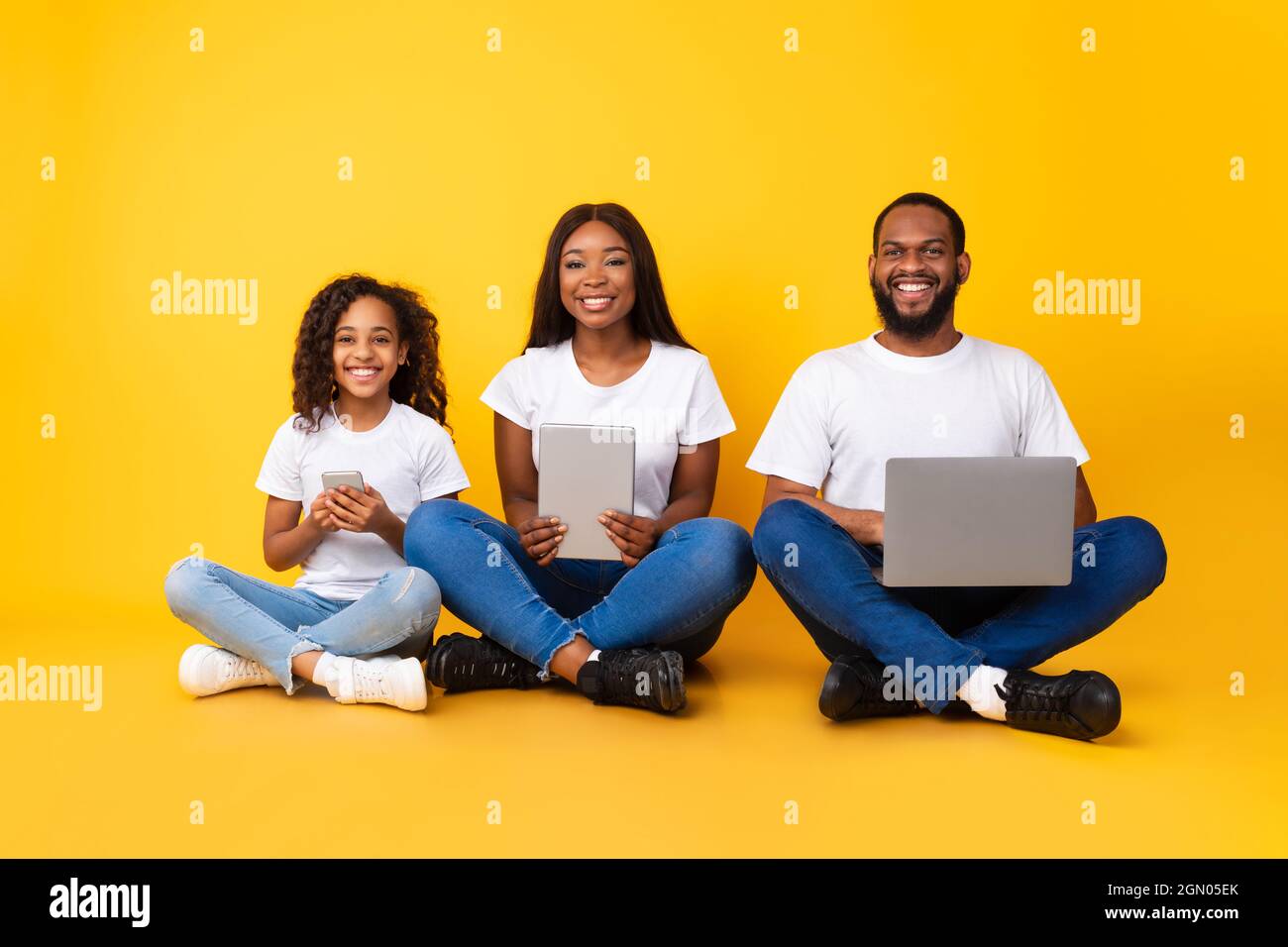 Happy african american family holding and using different gadgets Stock ...
