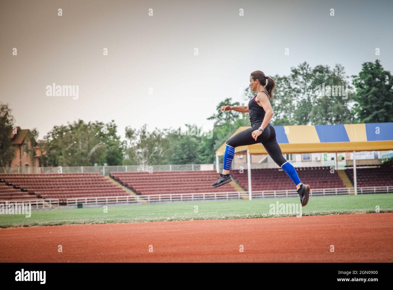 Young athletic woman stretches and prepares to run. strong sport woman ...