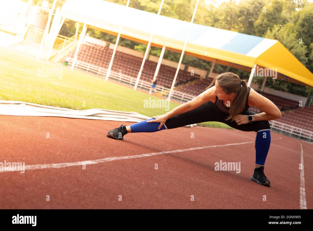 Young athletic woman stretches and prepares to run. strong sport woman ...
