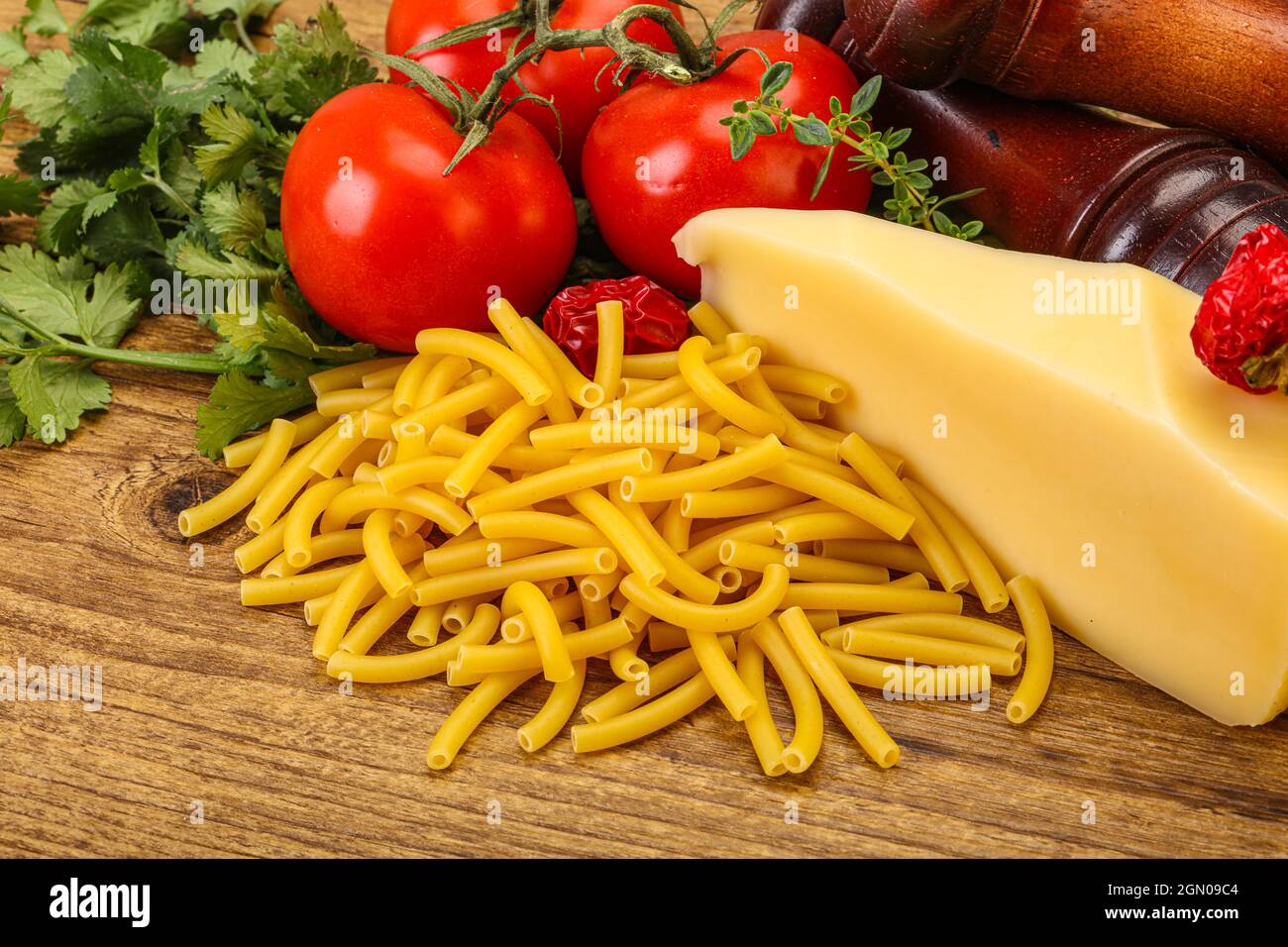 Italian pasta raw Maccheroni for cooking served vegetables Stock Photo ...
