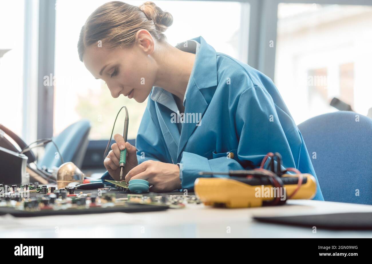 Worker in electronics manufacturing soldering a component Stock Photo ...