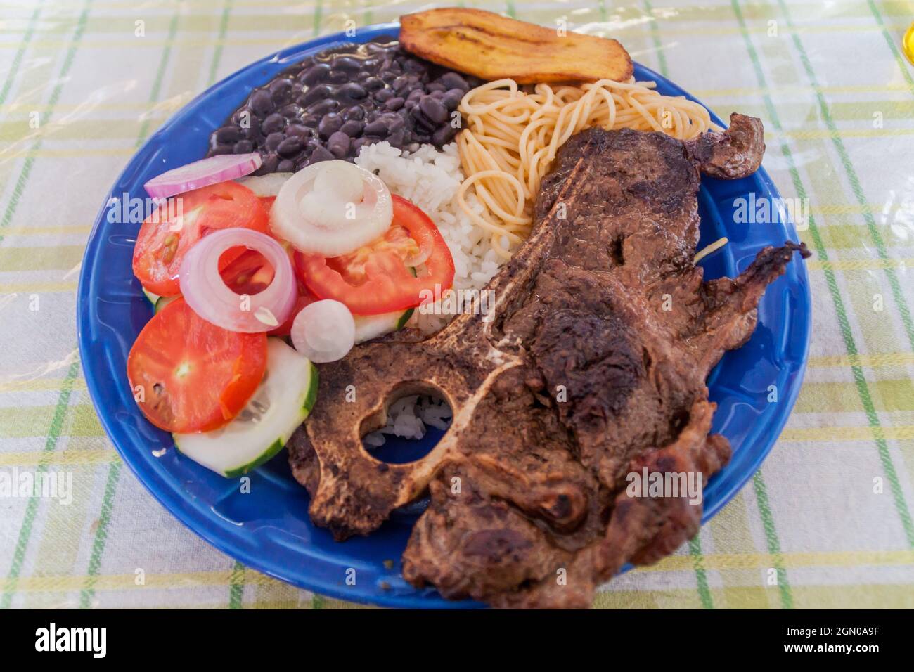 Meal in Venezuela. Rice and beans, plantain, pasta, meat and salad ...