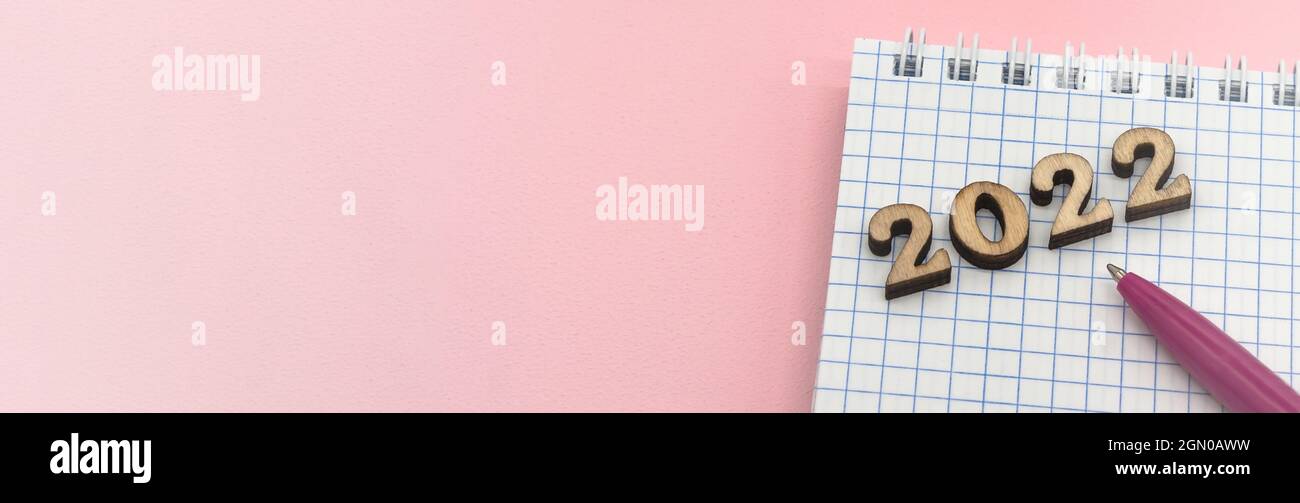 Wooden numbers 2022. Notepad on a spring. Notepad and Pen on Pink. Pink ...