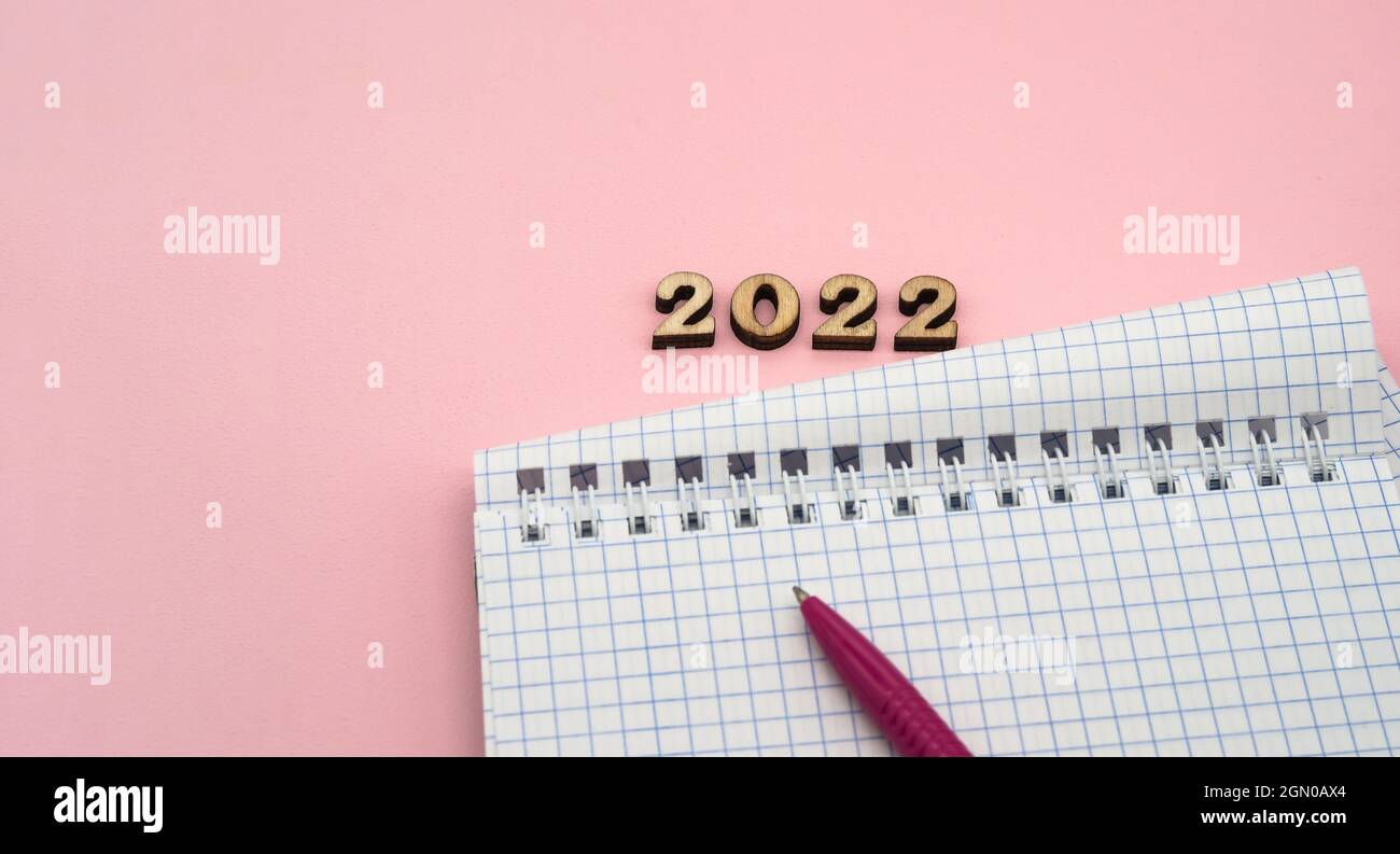 Wooden numbers 2022. Notepad on a spring. Notepad and Pen on Pink. Pink ...