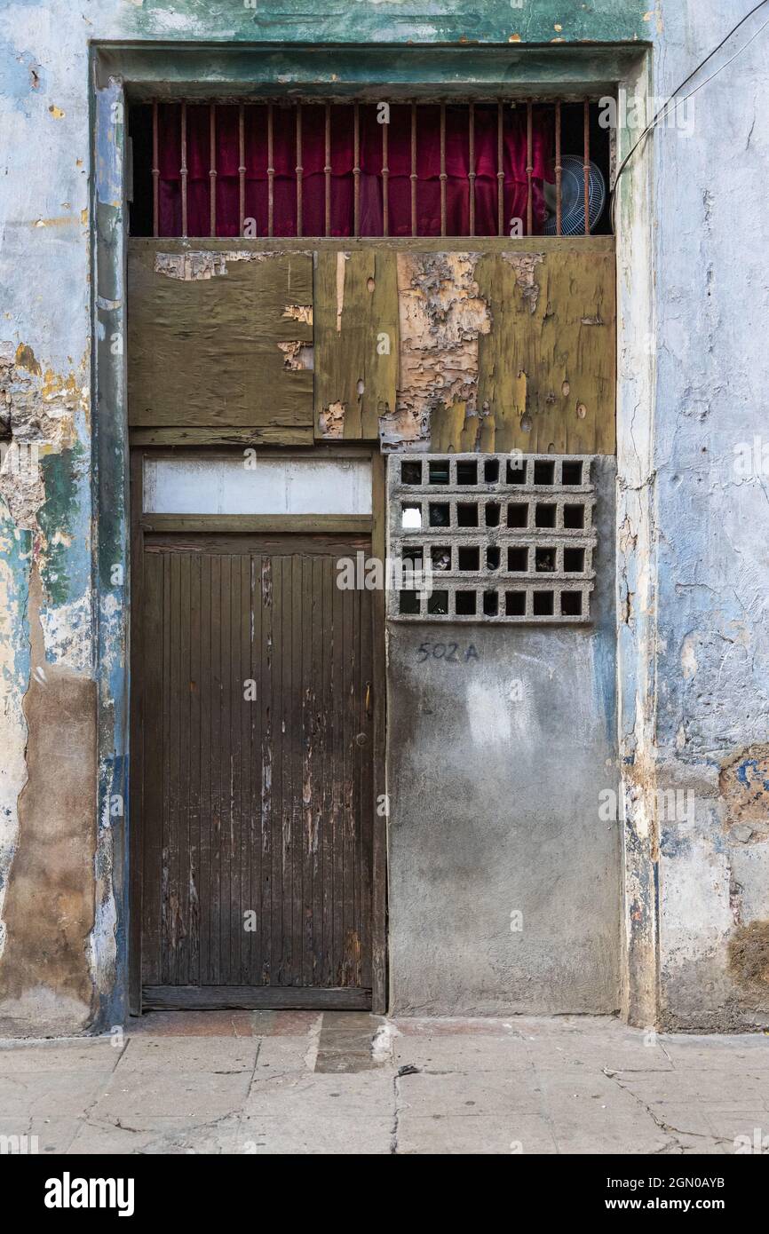 Vertical shot of entrance door in weathered old facade outside in ...