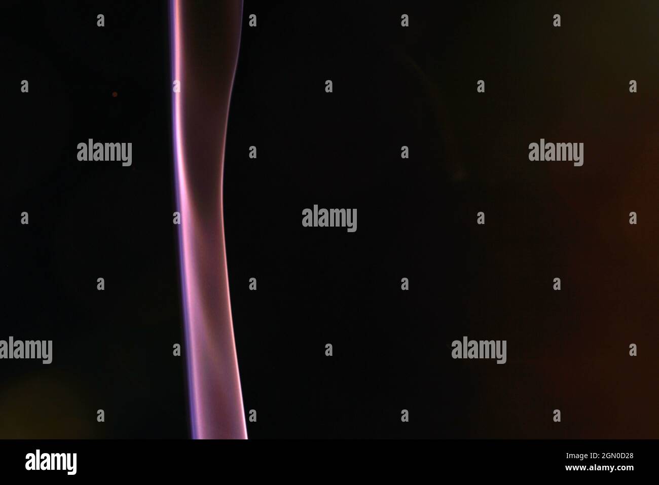 Thin streak of colored smoke photographed in the studio on a dark ...