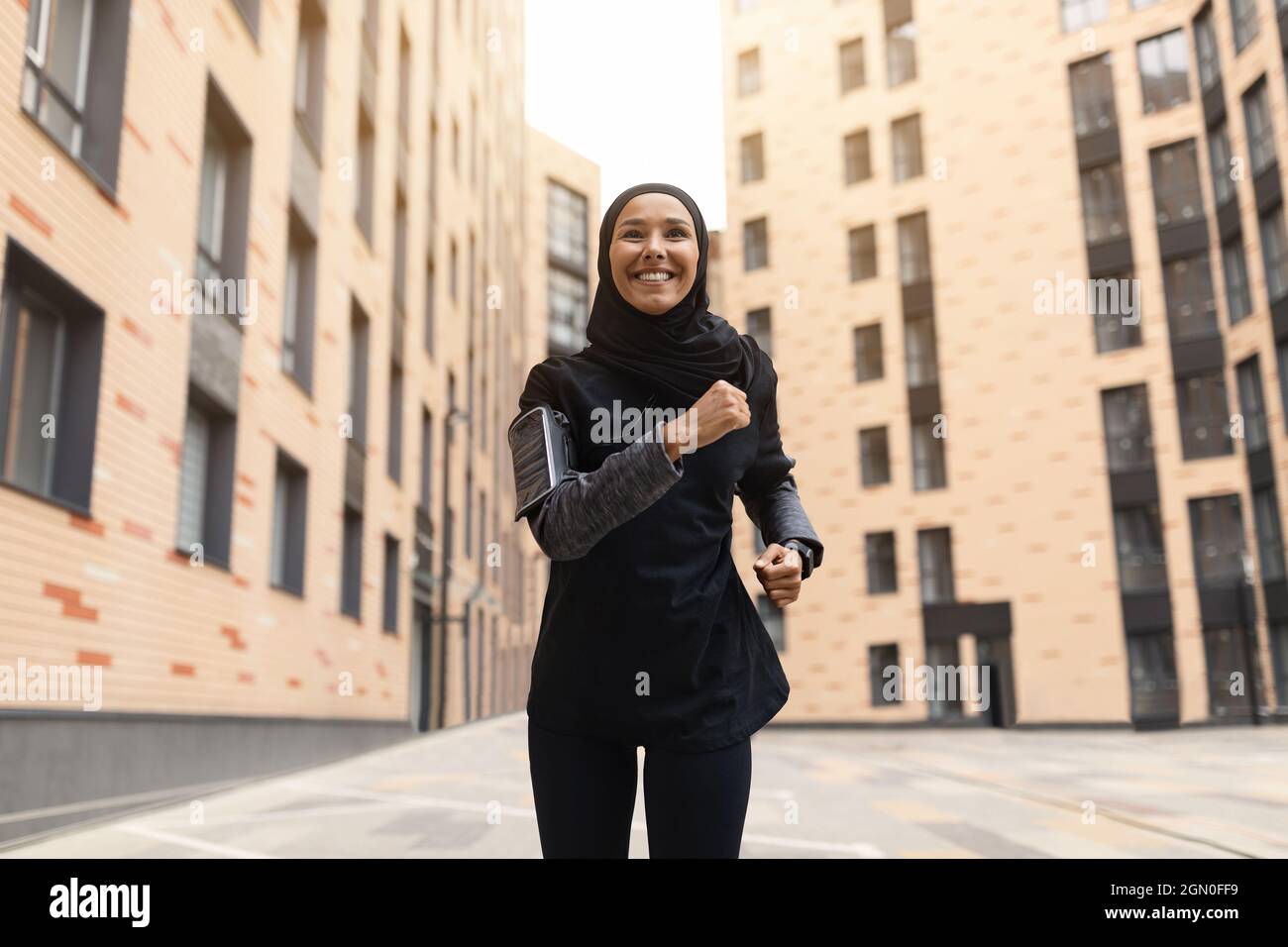 Sport For Muslim Women. Islamic Lady In Hijab Running On City Streets ...