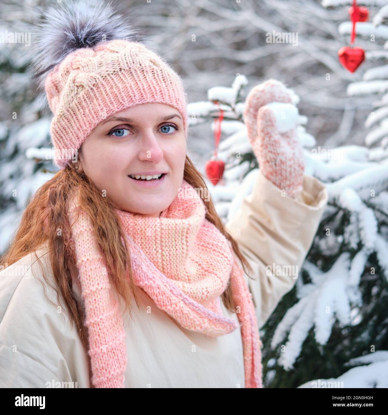 Woman playing snowballs by the christmas tree in winter nature on new ...