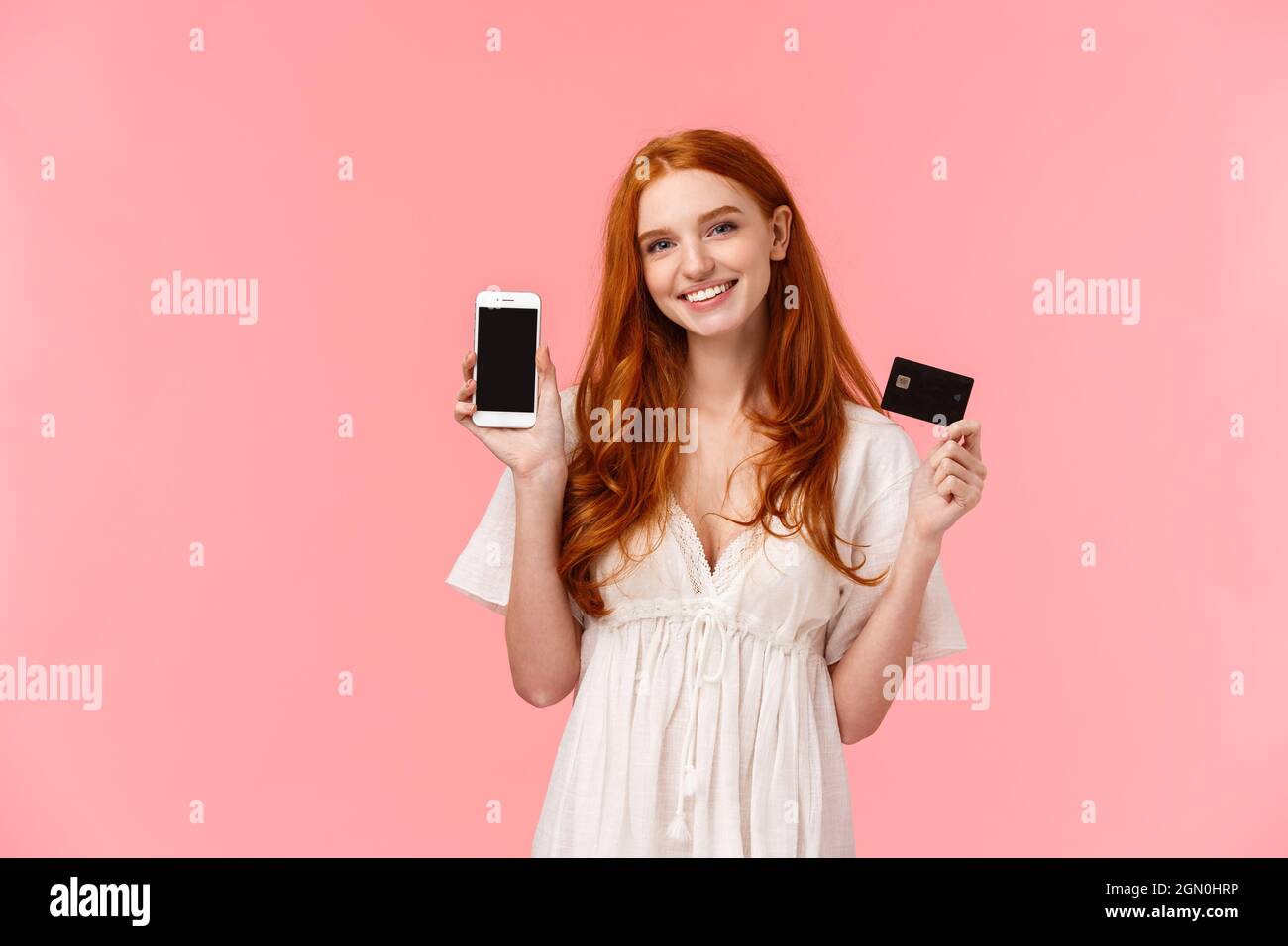 Girl promoting application on mobile display. Cheerful, lovely redhead ...