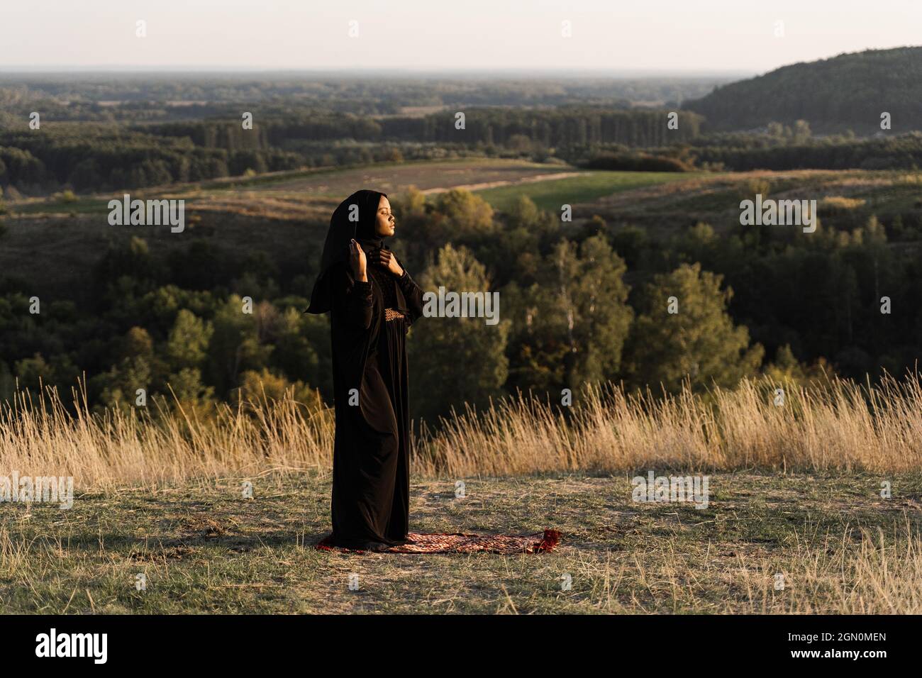Black muslim woman praying on the carpet. Solat praying on the ...