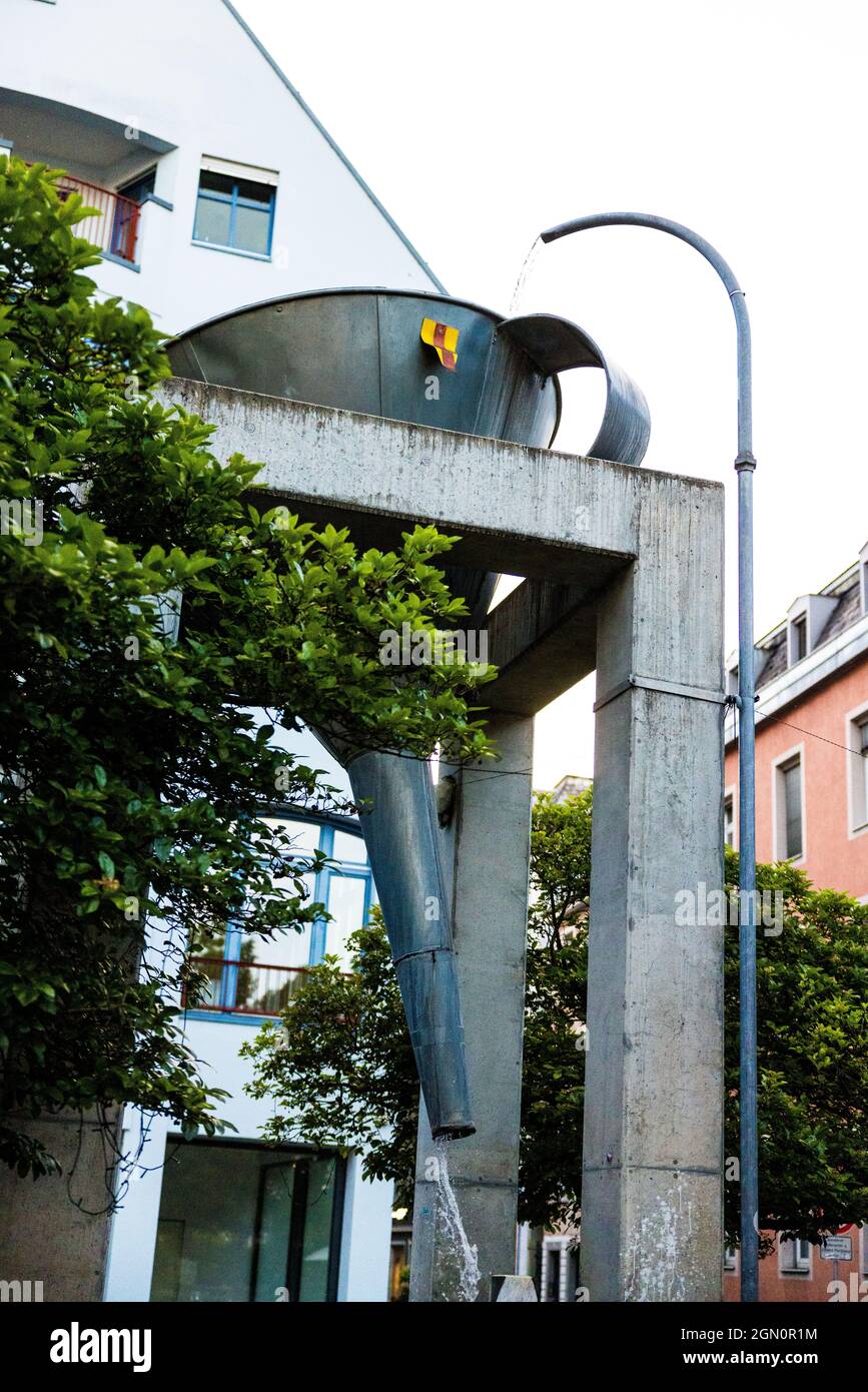 Huge metallic funnel with water on a background of a house and the sky ...