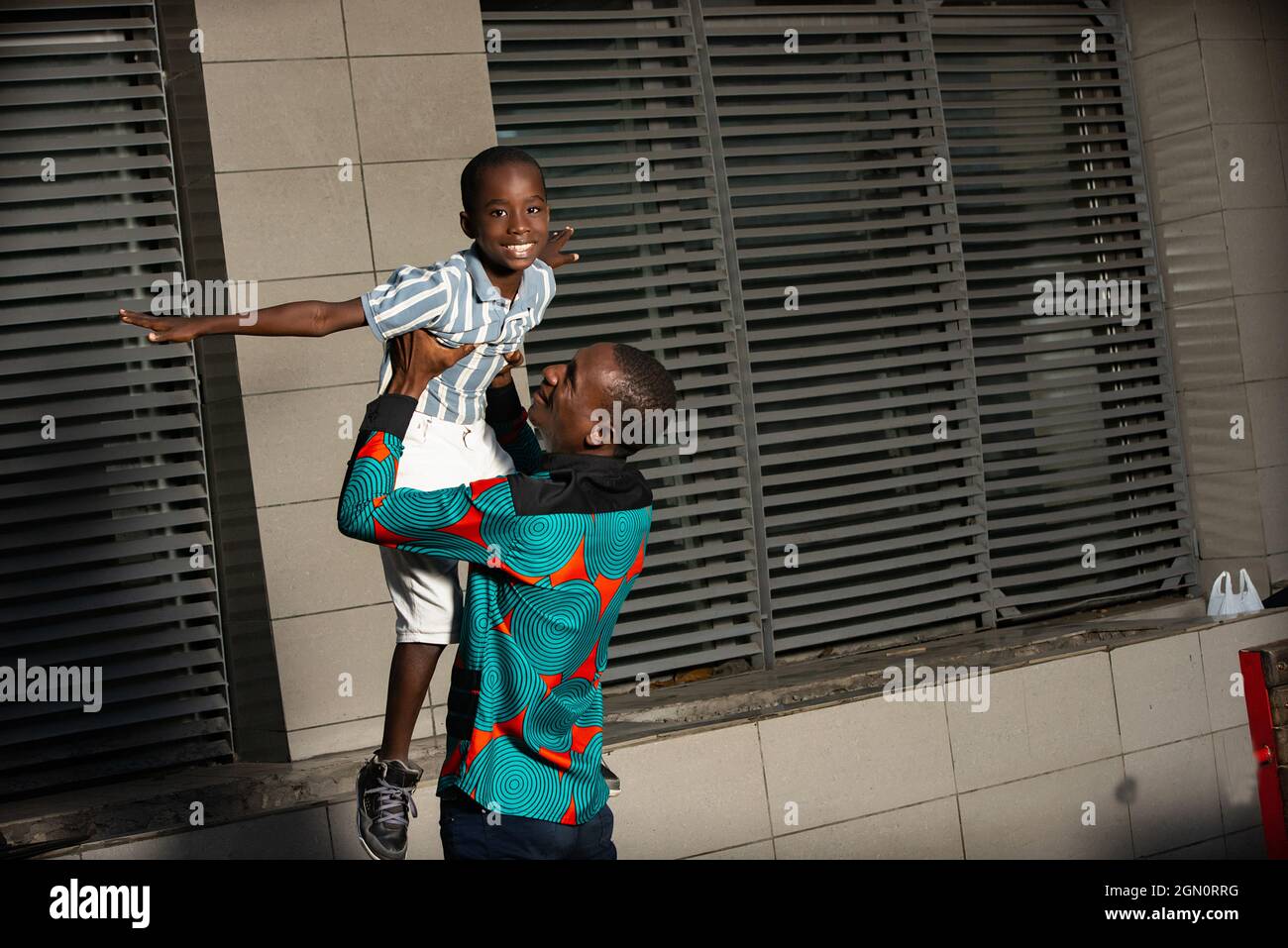 young african father raising his beautiful baby boy in the air. The boy ...