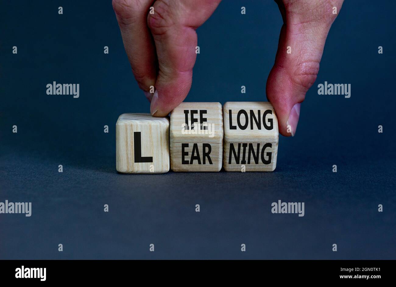 Lifelong learning symbol. Businessman turns wooden cubes with concept ...