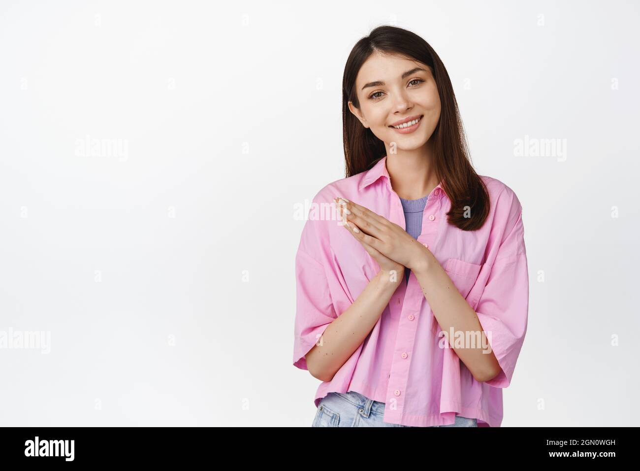 Pleased smiling girl clap hands and looking with thankful emotion ...