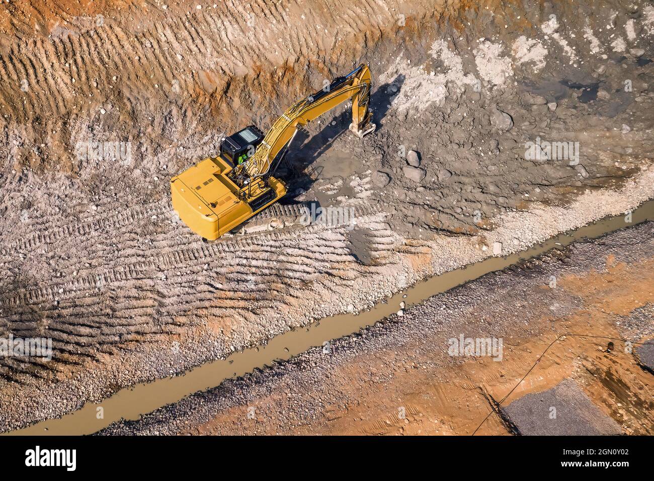 Heavy excavator ripping big stones from mountain ground with help of ...