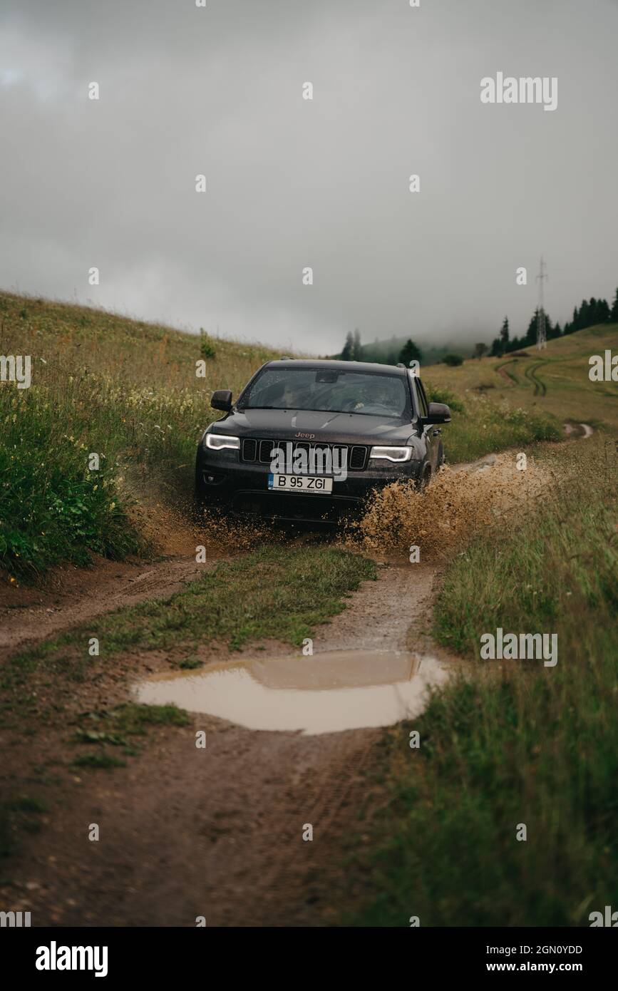 A SUV going through a mud puddle in an offroad environment Stock Photo ...