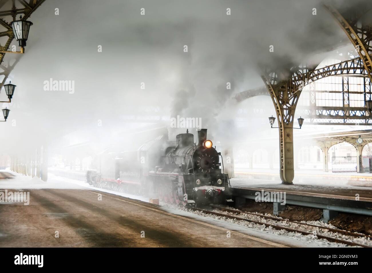 Steam locomotive stands on the platform of the station, winter cold ...