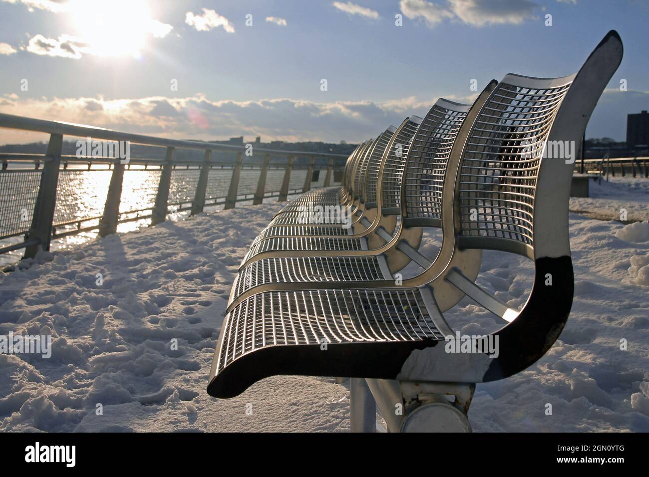 The metallic benches with the sunset in a cold winter scene in New York ...