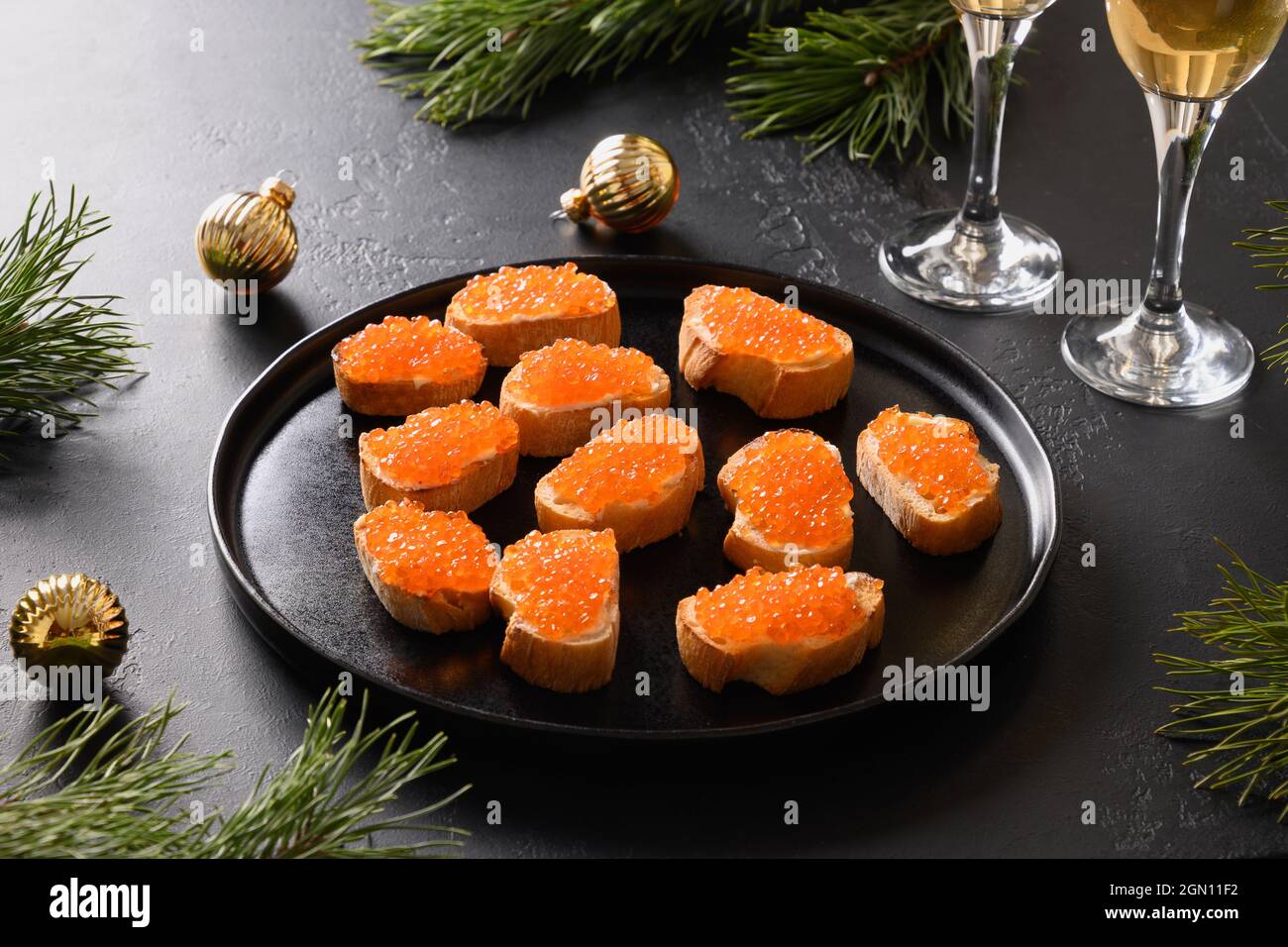 Festive Christmas canape with red caviar on ciabatta on a black ...