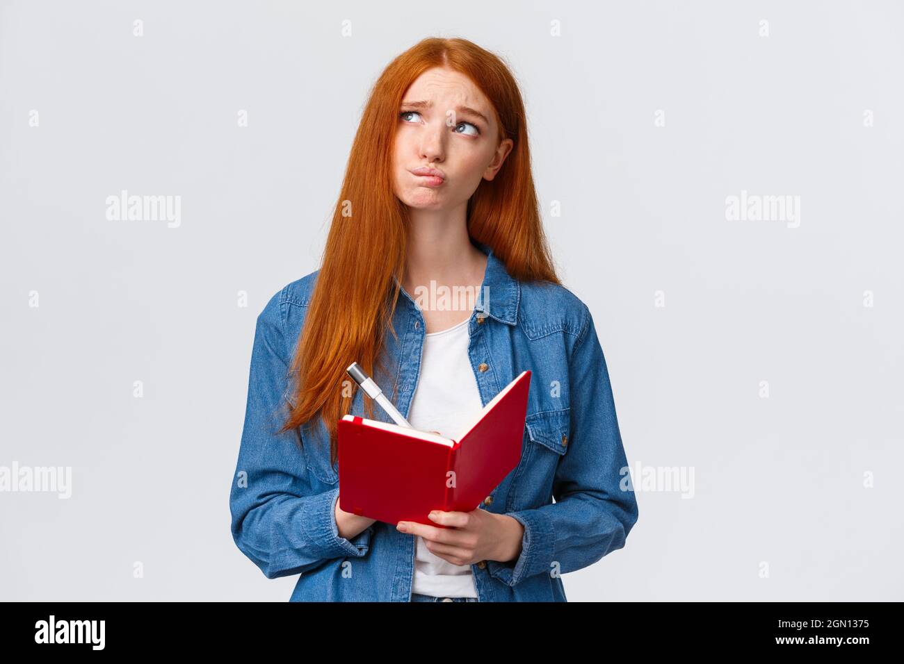 Uneasy and gloomy, indecisive cute redhead girl writing down her ...