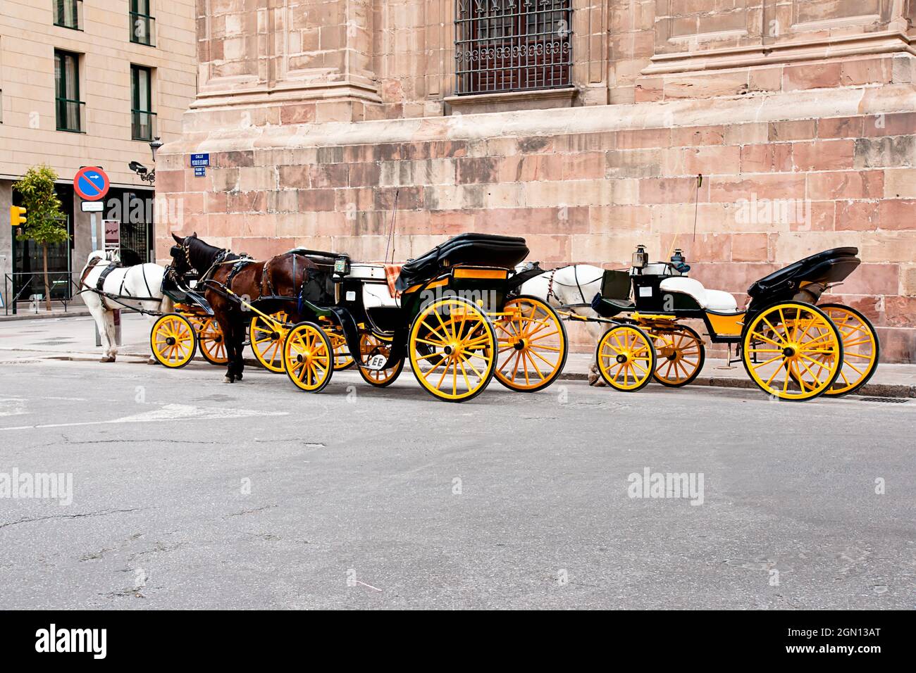 Beautiful horse carriage with yellow wheels on the streets of Malaga ...