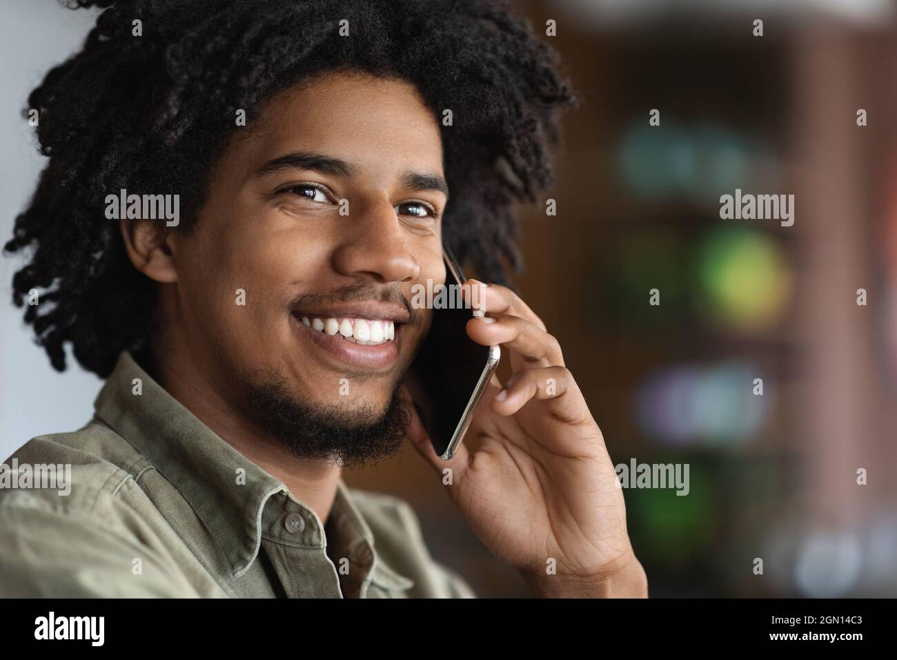 Portrait Of Young African American Guy Talking On Cellphone In Cafe ...