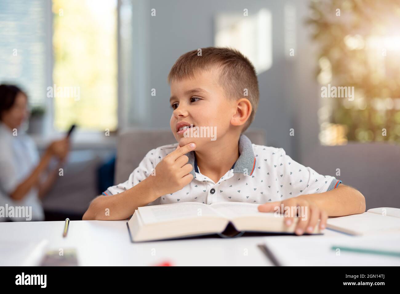 Thoughtful boy reading book Stock Photo - Alamy