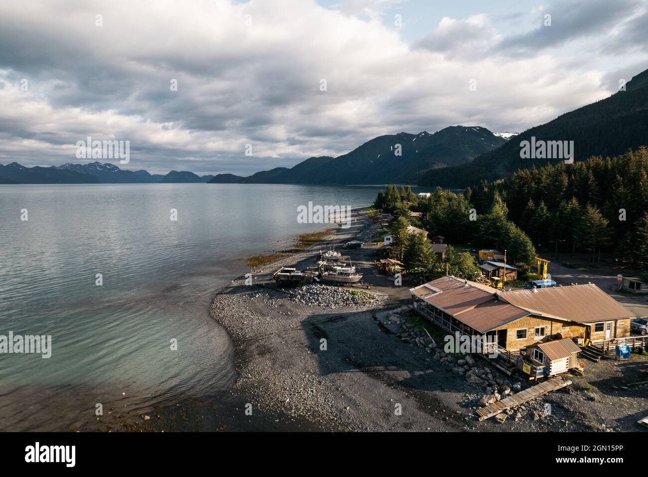Aerial shot of a rural town surrounded by a lake and mountains in ...
