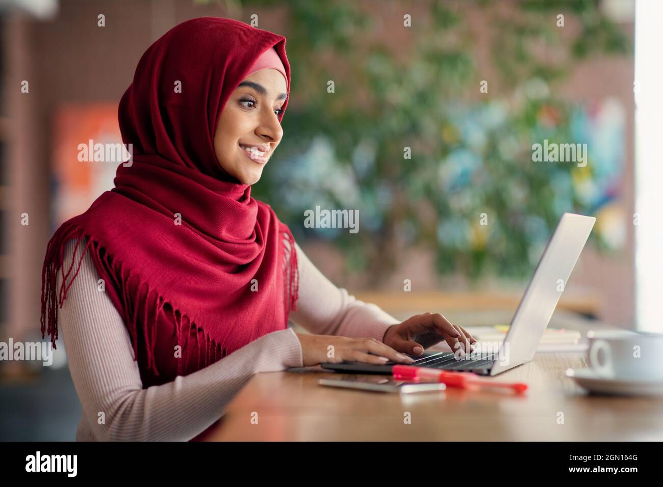 Religious muslim woman typing on laptop keyboard, cafe interior Stock ...