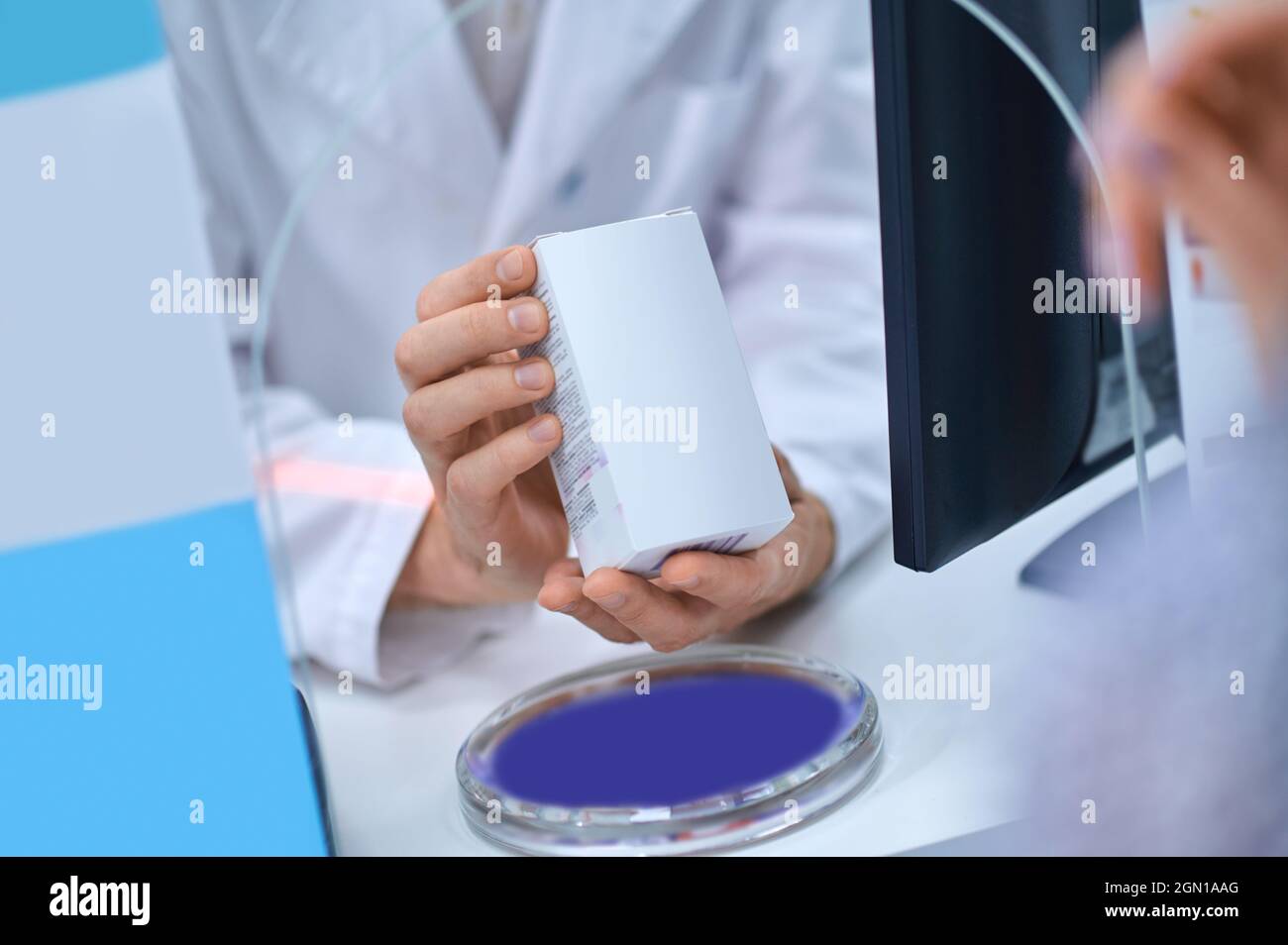 Pharmacy worker hands showing medicine packaging Stock Photo - Alamy