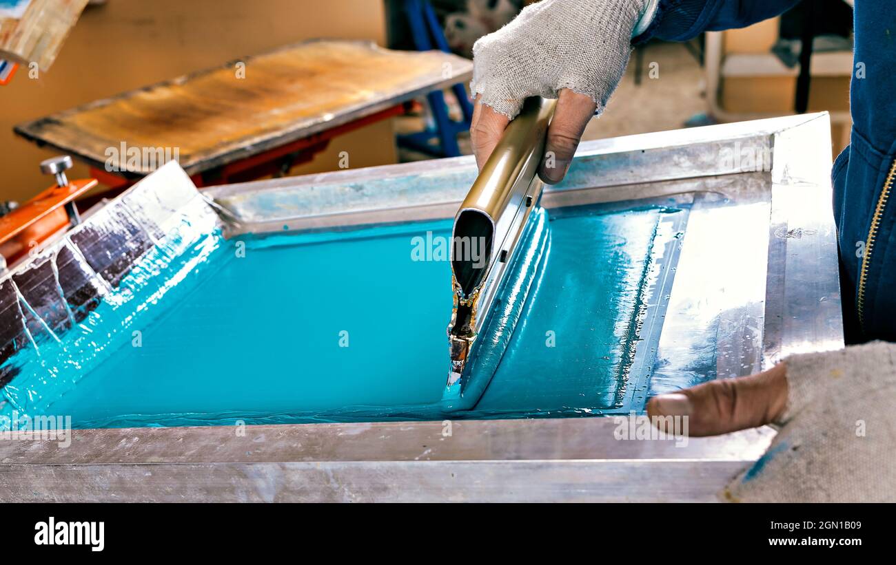 male hand with a squeegee. serigraphy production selective focus photo ...