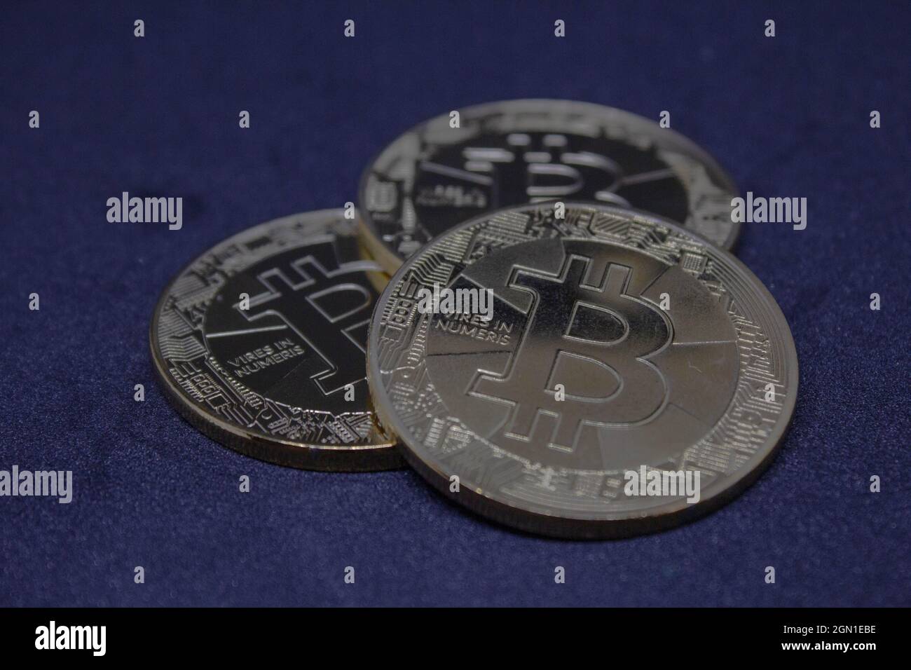 Bitcoins on different colored surfaces. Bitcoin is the most valuable ...