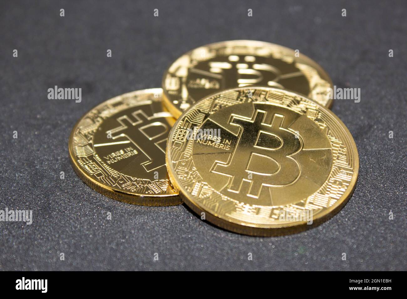 Bitcoins on different colored surfaces. Bitcoin is the most valuable ...