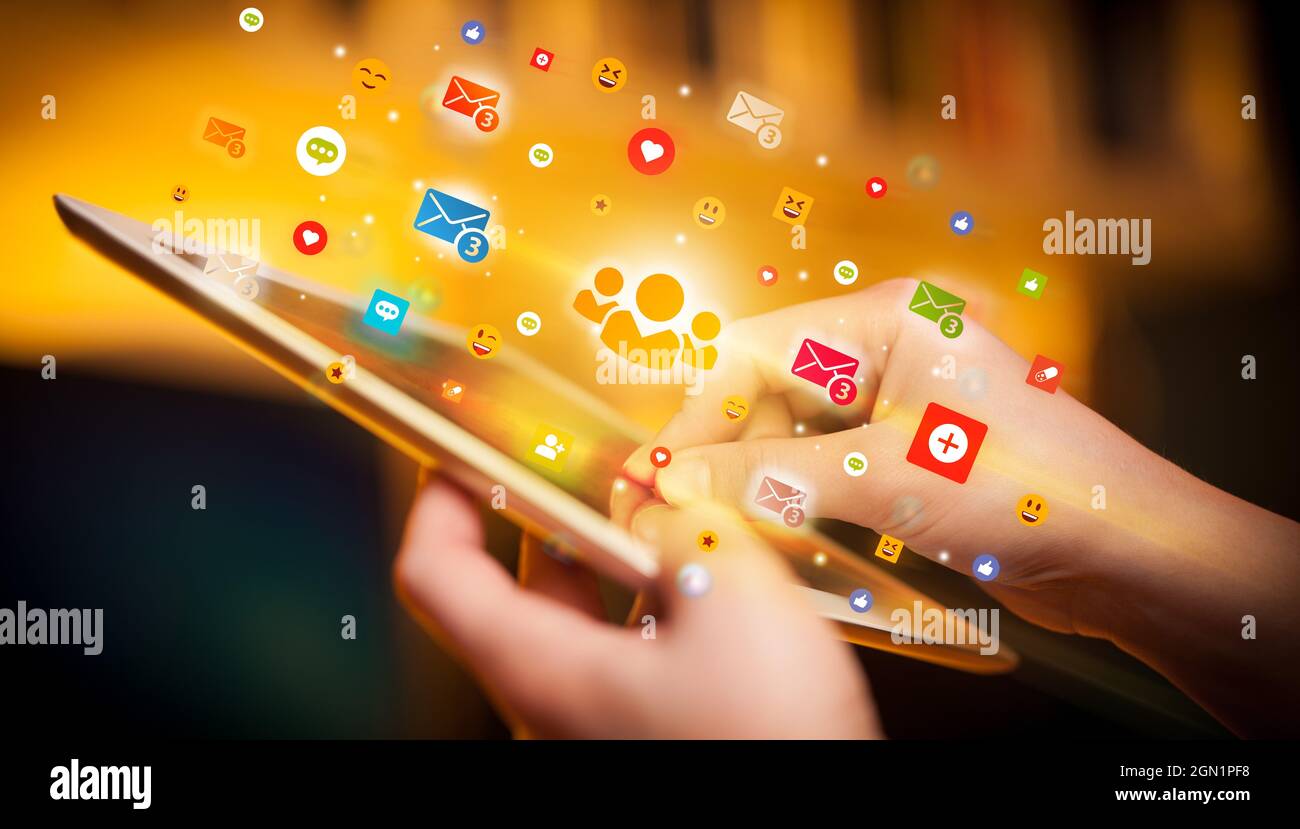 Close-up of a hand using tablet with social media icons Stock Photo - Alamy