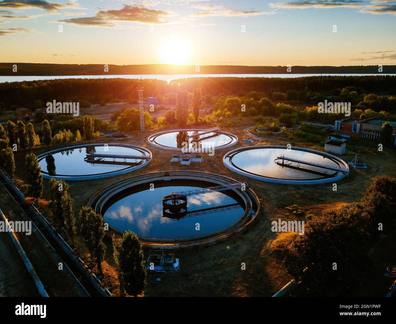 Modern sewage treatment plant. Wastewater purification tanks at sunset ...
