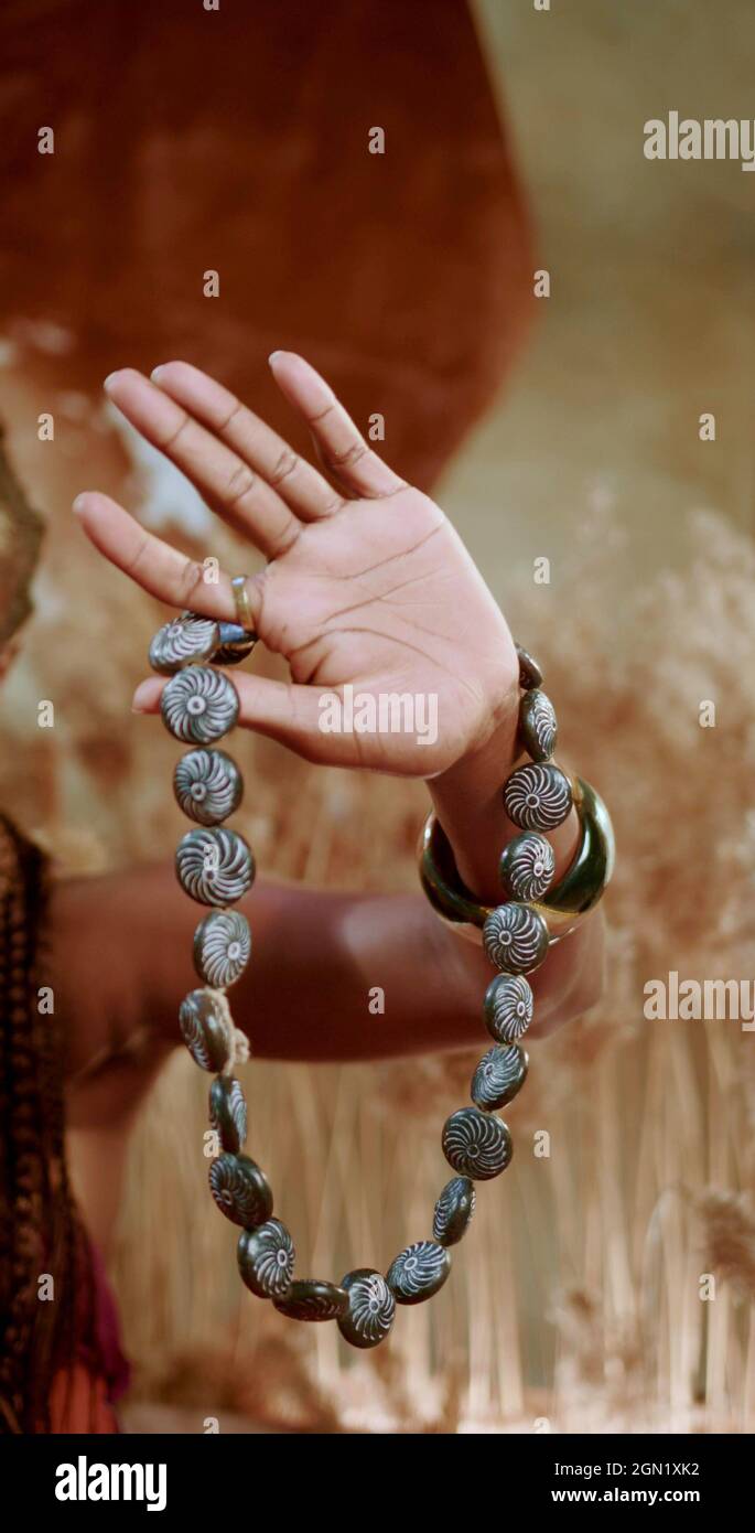 A vertical photo of an African hand which is holding a traditional ...