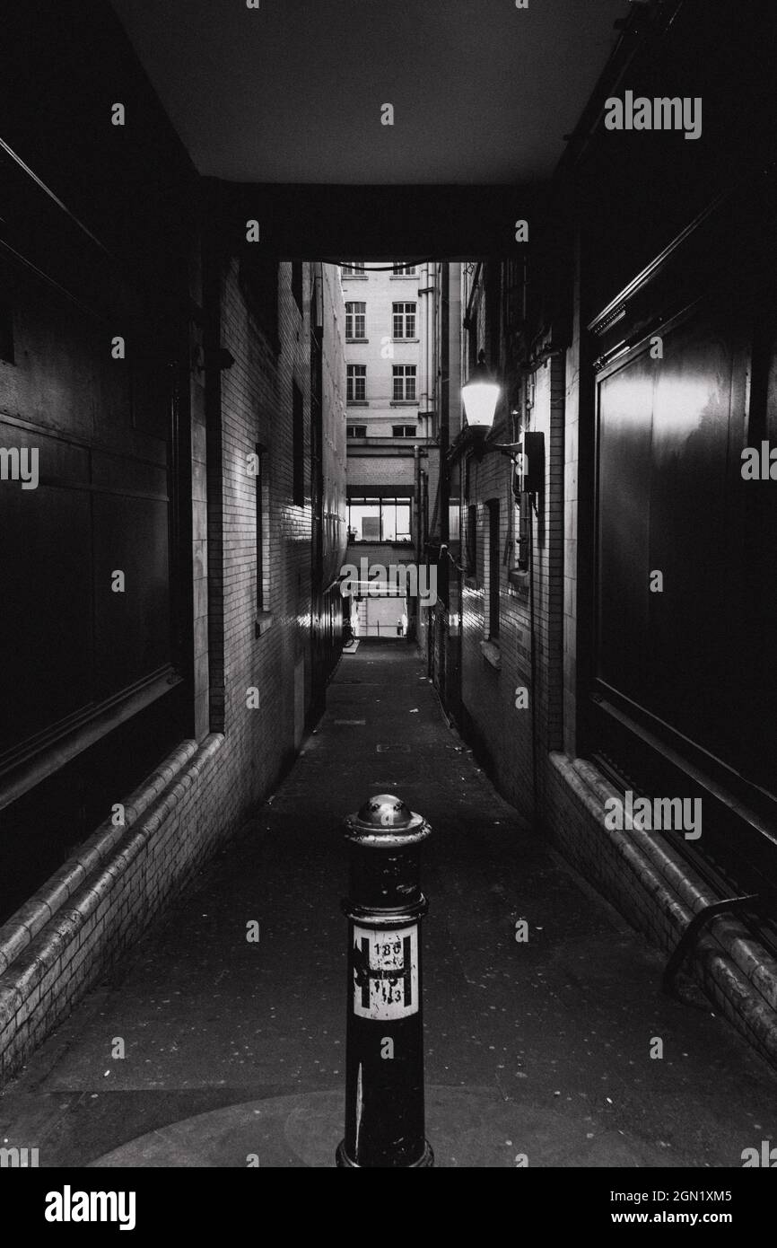 Grayscale of a narrow corridor between buildings Stock Photo - Alamy