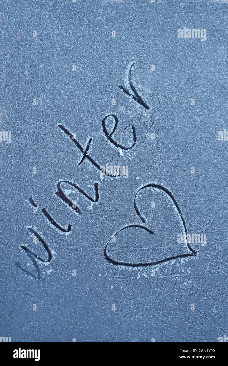 Winter. Frozen glass lettering.Winter word and heart on frozen surface ...