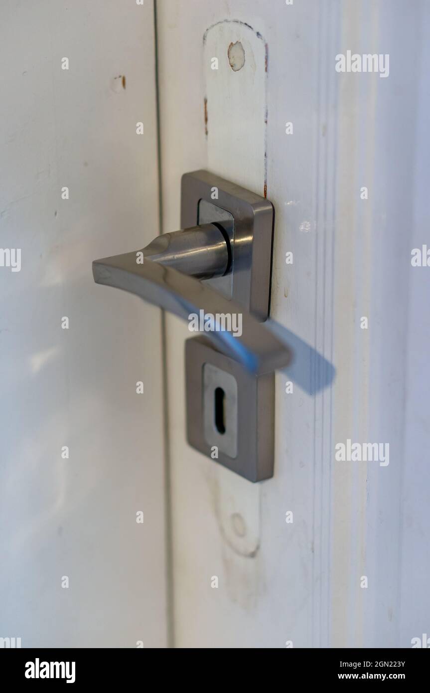Vertical shot of metal handle on a white door Stock Photo - Alamy