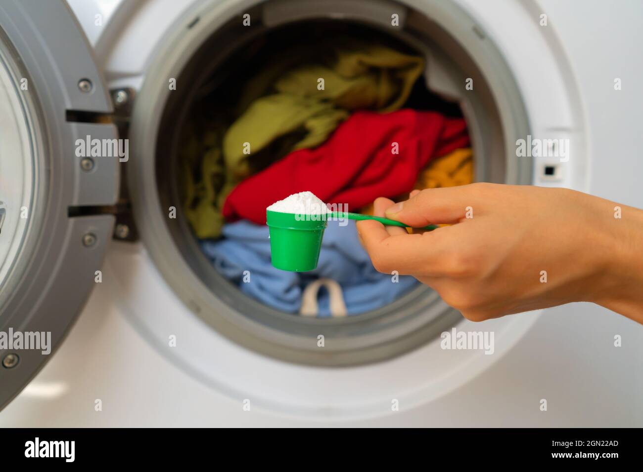 Female hand holds a cap with washing powder Stock Photo - Alamy
