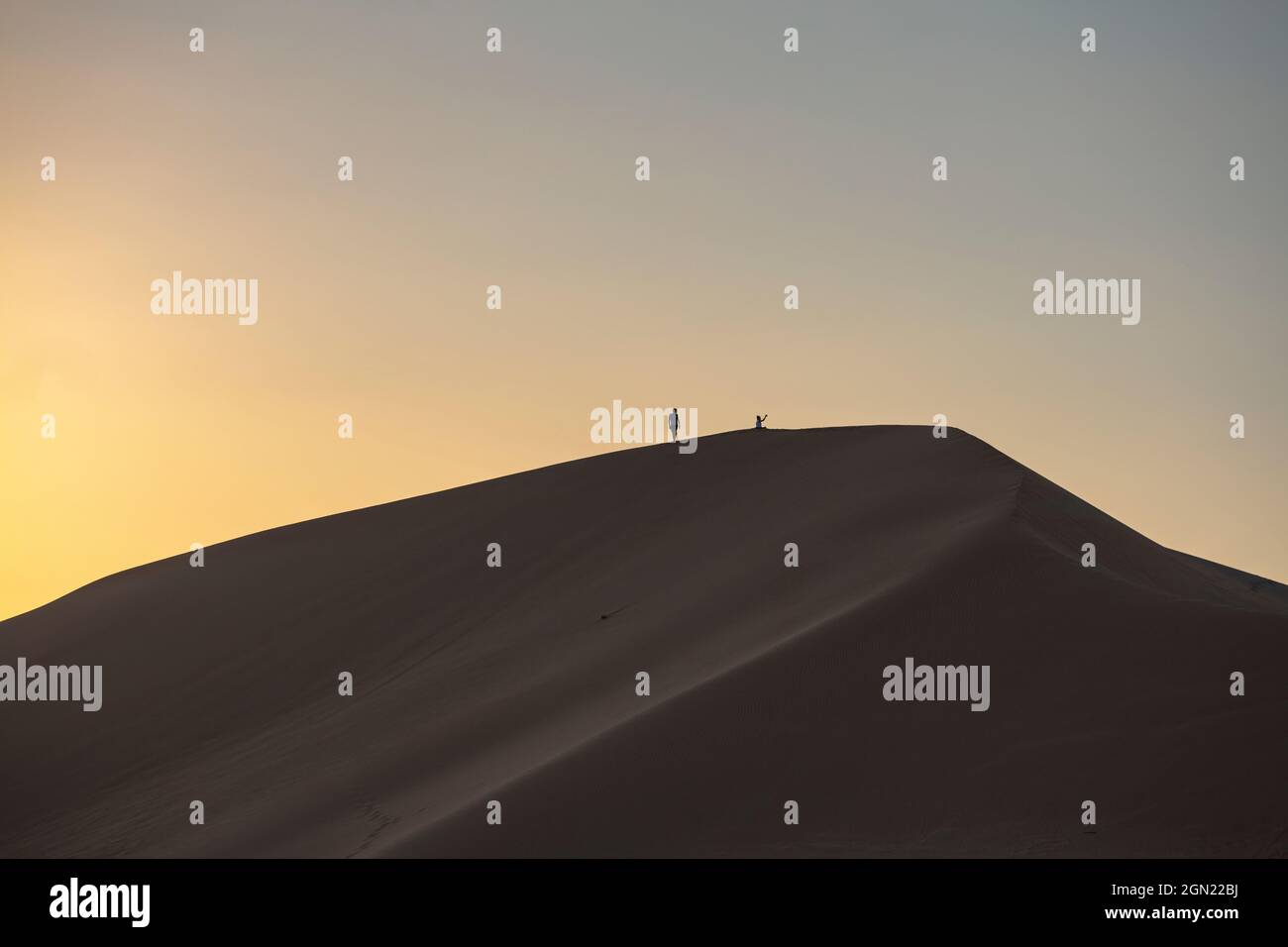 Silhouette of people on sand dune outside Arabian Nights Village desert ...