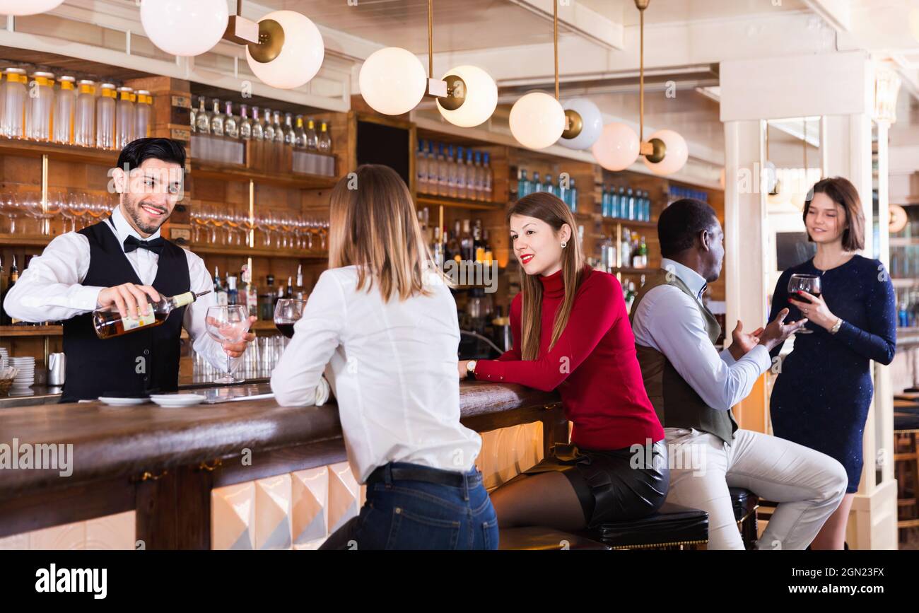 Portrait of barman and people who are standing near bar counter in ...