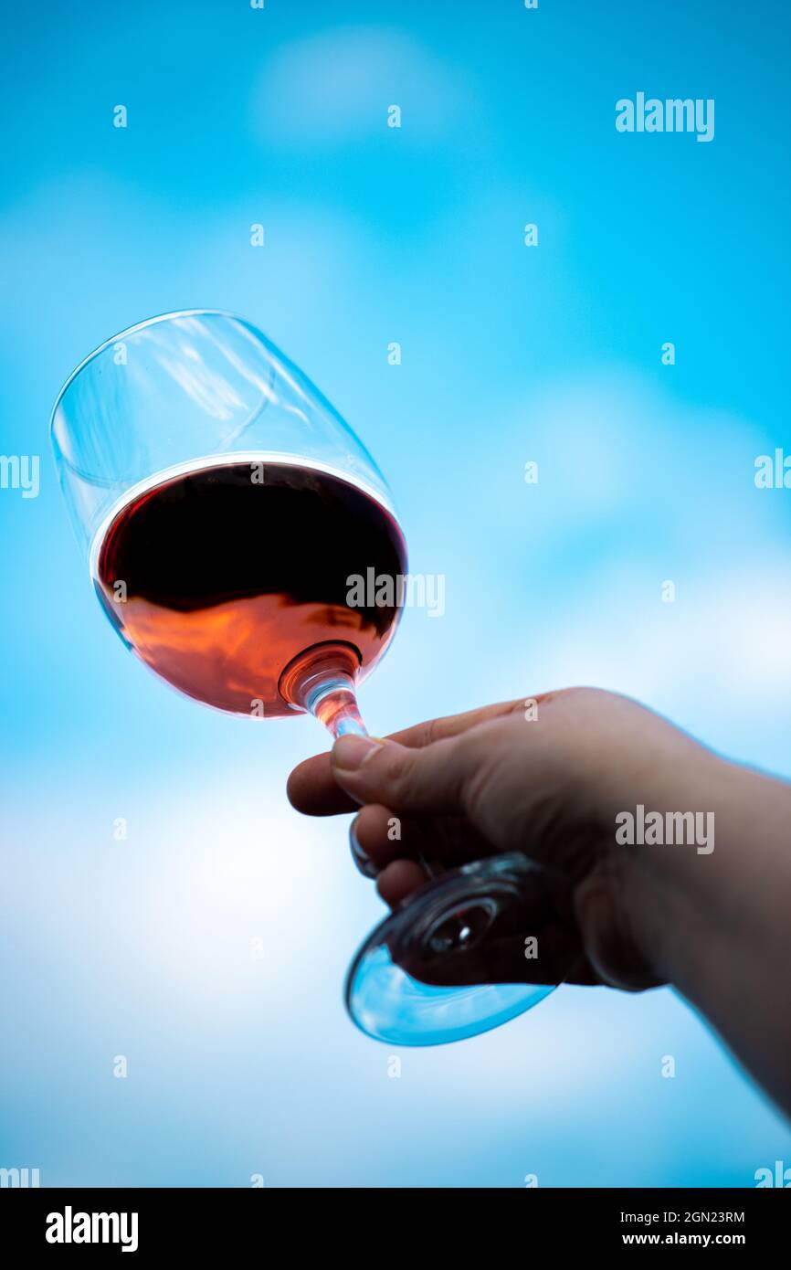 Hand tossing a glass of red wine into the air Stock Photo - Alamy