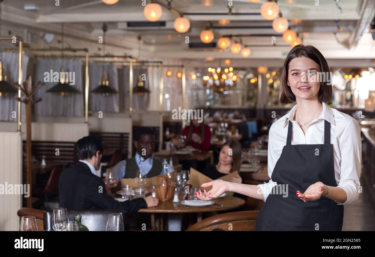Smiling waitress welcoming to restaurant Stock Photo - Alamy