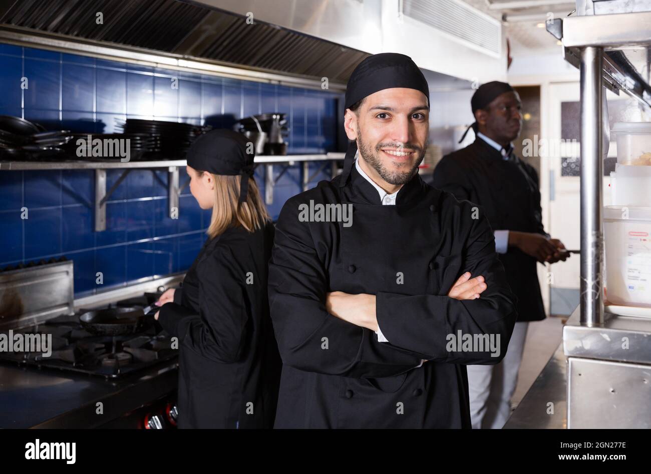 Smiling chef cook is posing on kitchen Stock Photo - Alamy