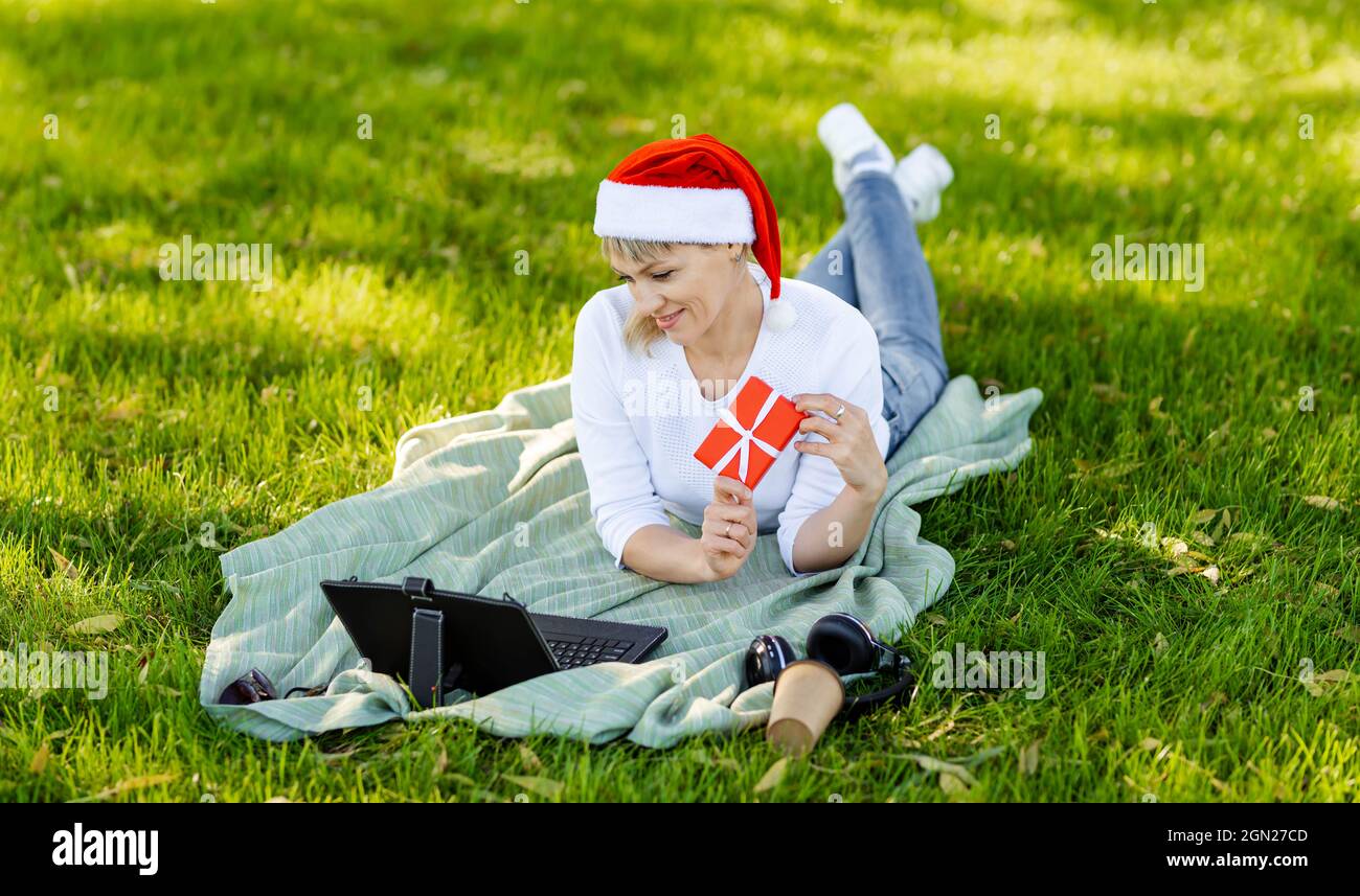 Cute female ordering presents on laptop. Online shopping. New Year ...