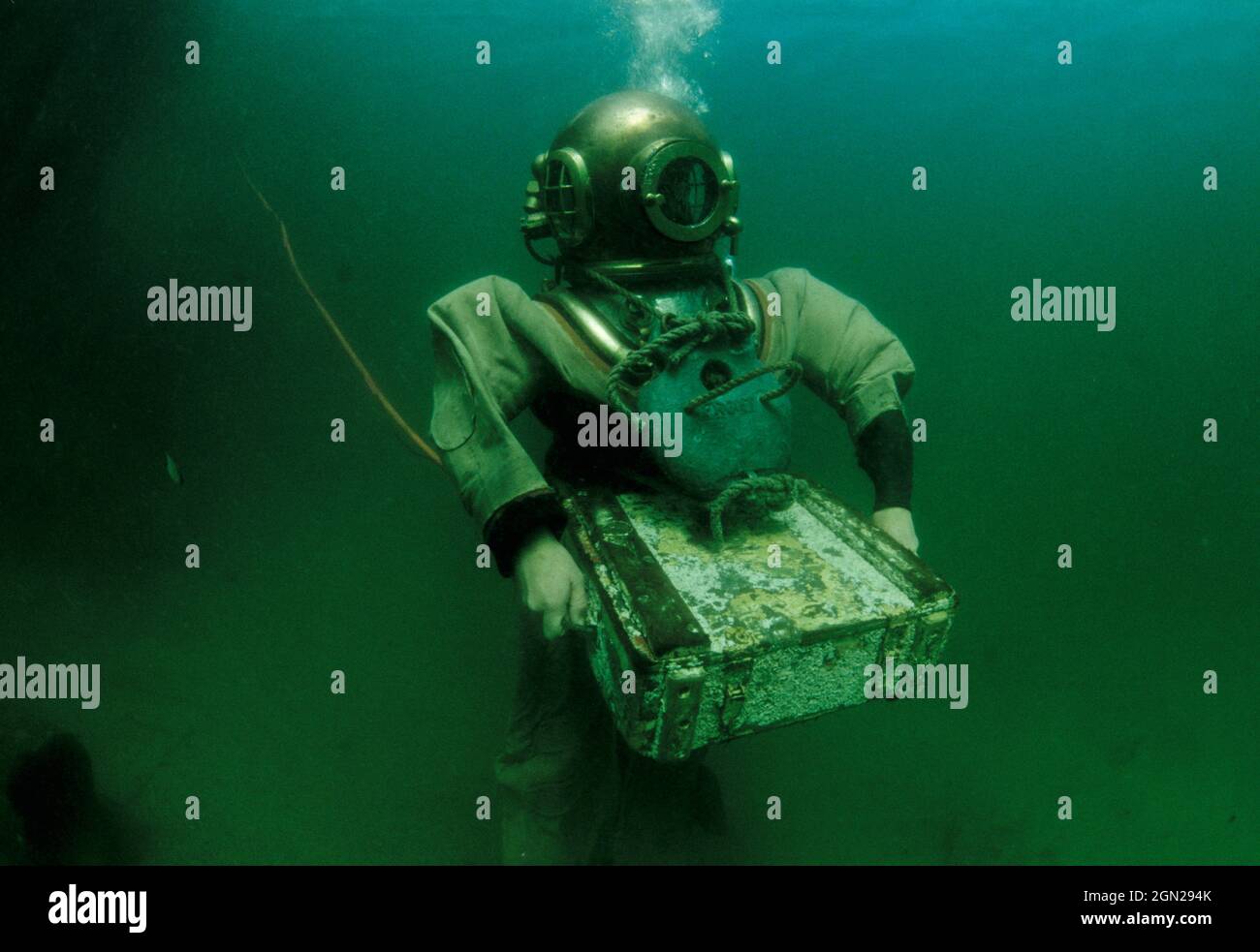 Hard-hat or ’standard dress’ diver with ammunitions box. He is from the ...