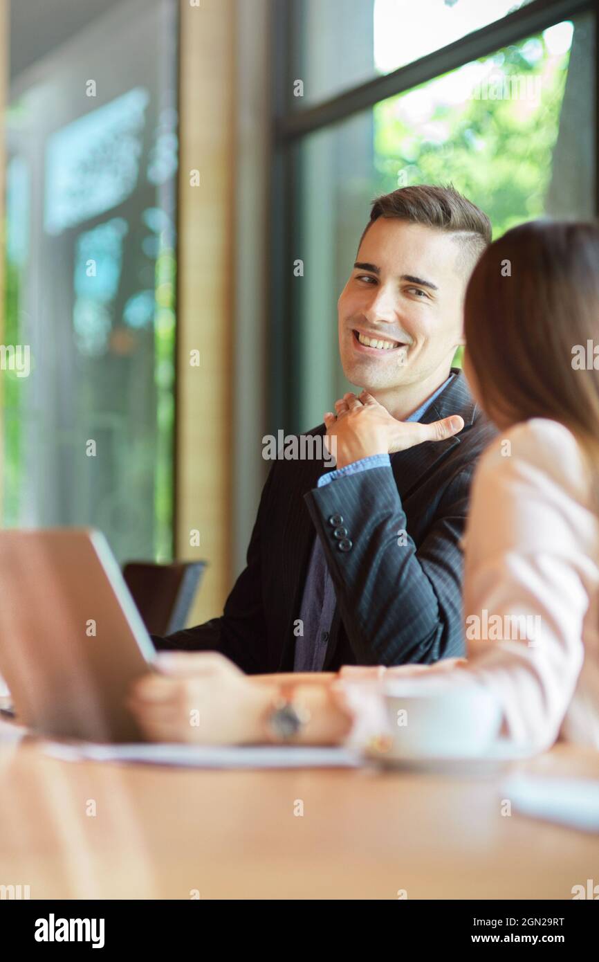 Happy and friendly businessman talking with his colleagues in the ...