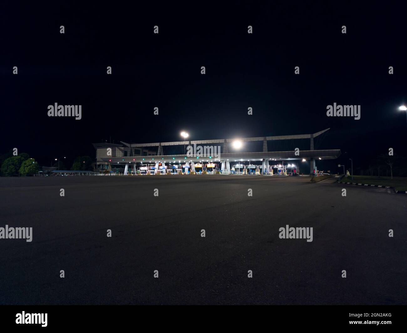 A wide view of the toll plaza at night with floodlights. Selective ...