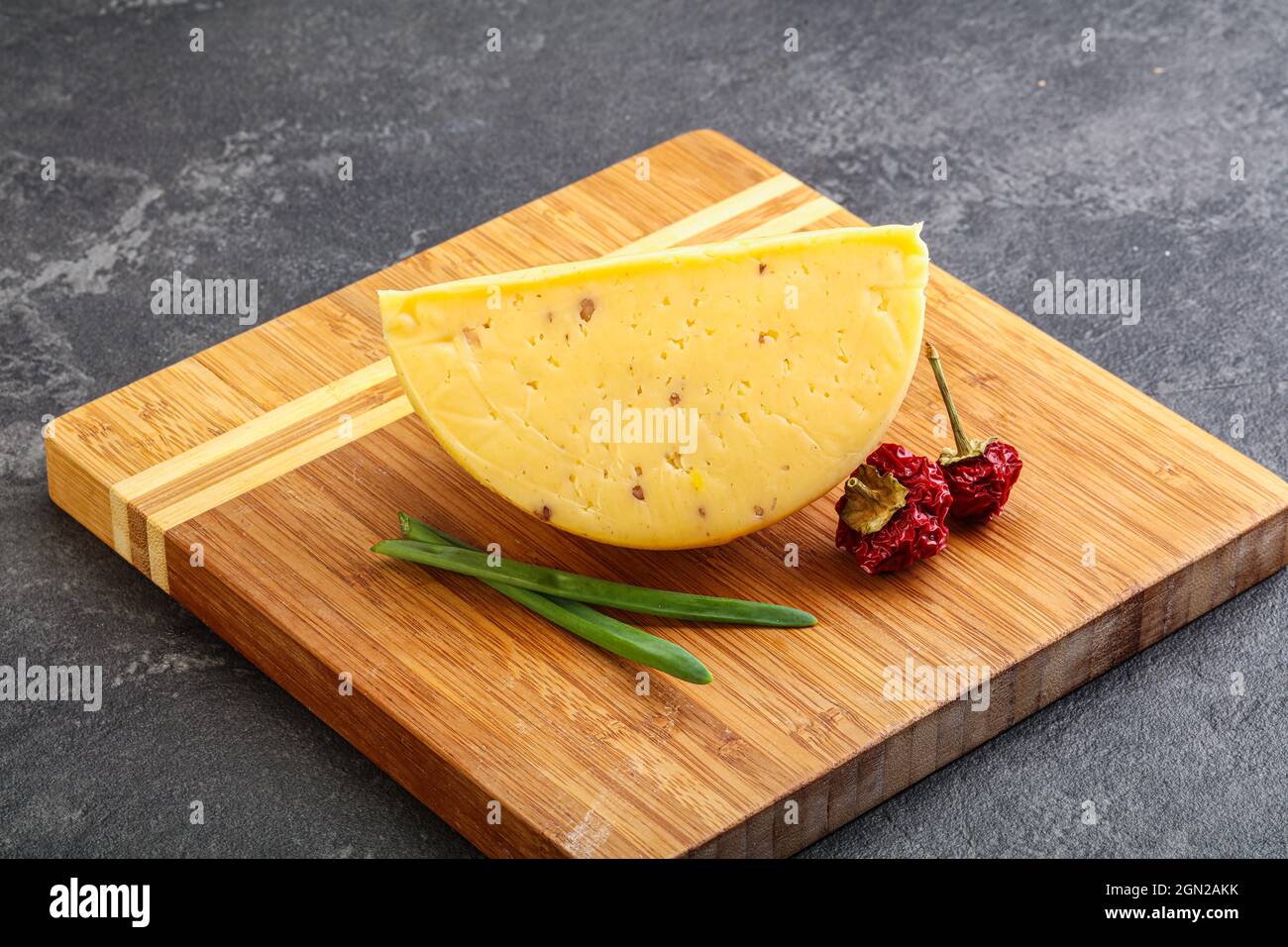 Hard cheese brick with walnut over board Stock Photo - Alamy